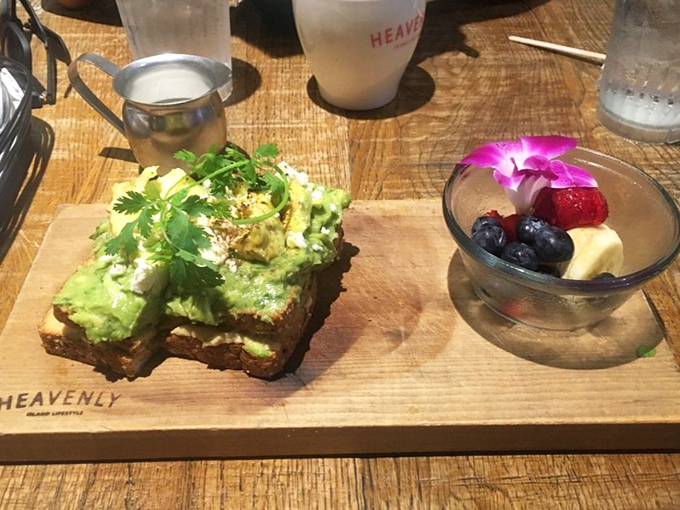 Avocado toast that actually deserves its Instagram fame, served with a side of fruit that looks like it was arranged by someone who cares.