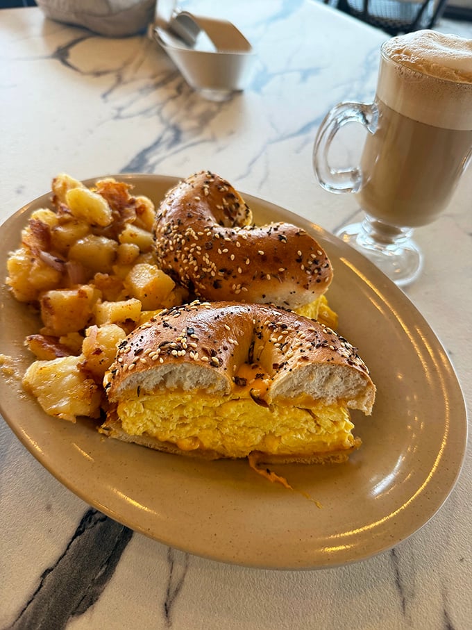 Breakfast nirvana: a golden-yolked egg sandwich on an everything bagel with home fries. The morning doesn't get better than this. 