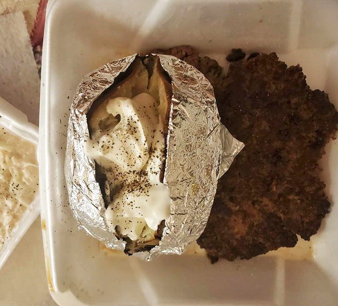 The humble baked potato, wrapped in its silver armor, stands ready beside what appears to be country-fried steak&mdash;comfort food that hugs your insides.