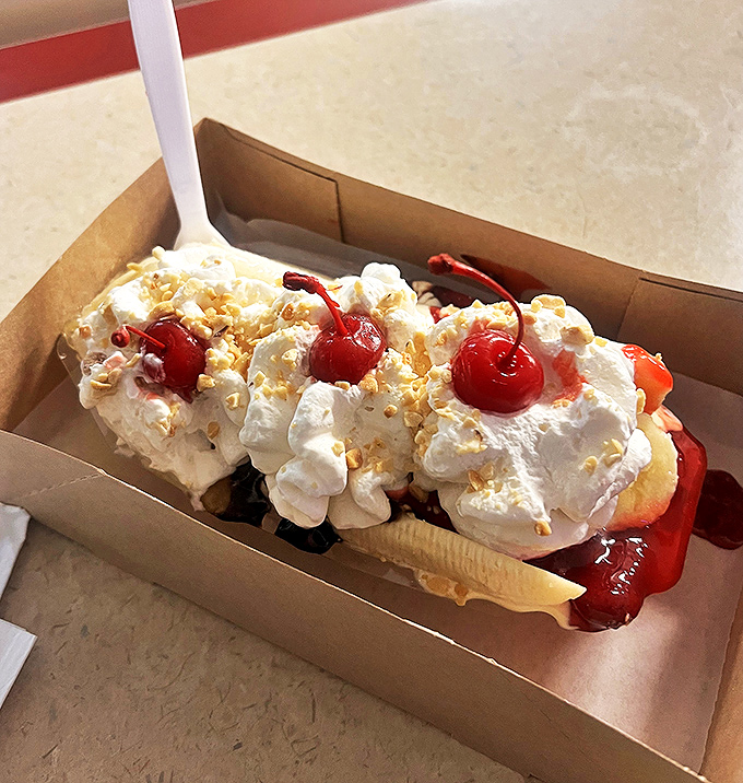 Behold the banana split in its natural habitat: a cardboard boat sailing on waves of whipped cream and cherry-topped glory.