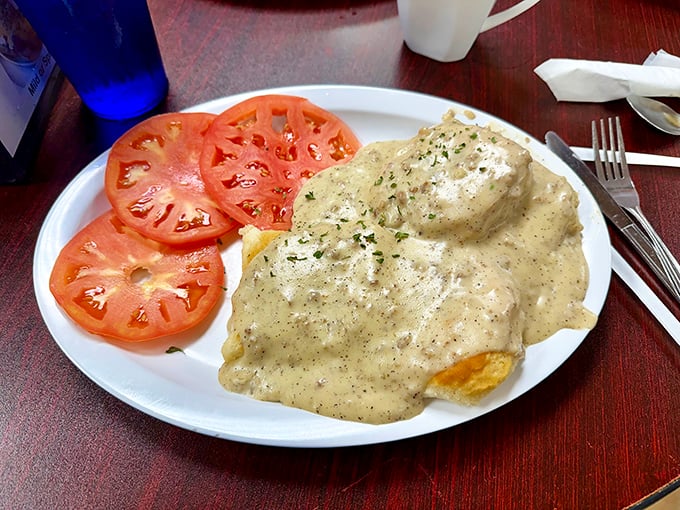 Biscuits smothered in pepper gravy alongside fresh tomatoes &ndash; Southern comfort food that whispers "take a nap after this."