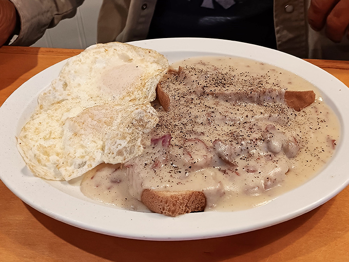 Biscuits and gravy with eggs sunny-side up &ndash; the kind of plate that makes you want to cancel your afternoon plans and surrender to a food coma.