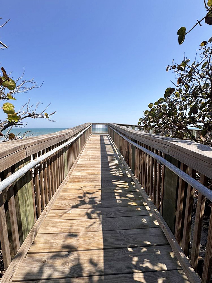 The wooden boardwalk creates a perfect frame for the ocean beyond. Each step brings you closer to that moment when worries dissolve into sea spray.