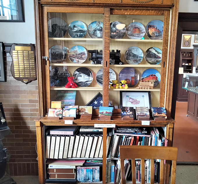 Railroad memorabilia displayed with loving care&mdash;each decorative plate capturing a moment in locomotive history. The bookshelf below holds treasures for the truly train-obsessed visitor.