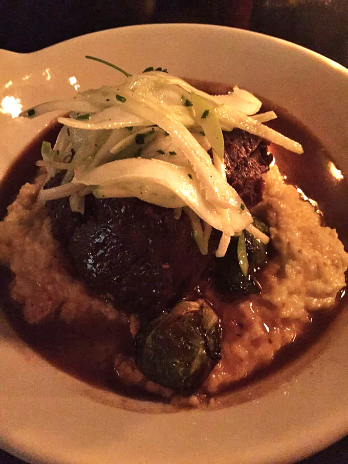 Comfort food elevated to an art form&mdash;tender braised short ribs nestled in creamy grits with crisp vegetables providing the perfect textural contrast.