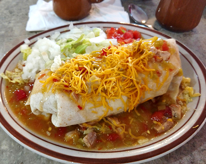 This breakfast burrito isn't just a meal, it's a morning masterpiece swimming in green chile sauce that would make New Mexico jealous.