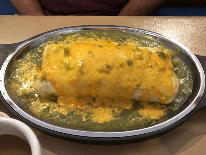 Behold the breakfast burrito in its natural habitat, swimming in green chile sauce. A tortilla-wrapped miracle that makes morning people out of night owls. 