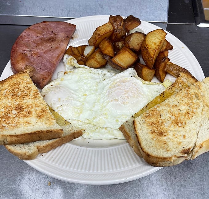 The holy trinity of breakfast perfection: golden home fries, perfectly cooked eggs, and toast that's achieved that mythical balance between crisp and tender.