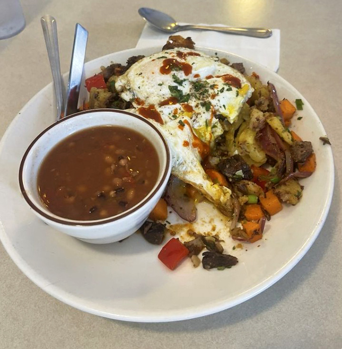 The Brisket Hash arrives like a beautiful breakfast mosaic&mdash;tender meat, colorful vegetables, and eggs that create their own sauce when broken.