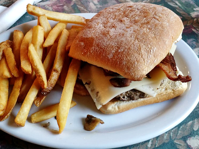 This isn't just a burger &ndash; it's architecture. Melted cheese cascading over mushrooms and bacon on a fresh-baked roll that somehow contains the delicious chaos.