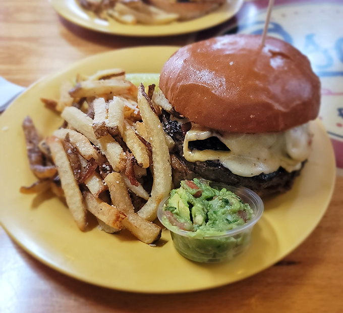 The burger arrives like a monument to beef perfection&mdash;a towering achievement of melted cheese, fresh-cut fries, and that little cup of guacamole for good measure.