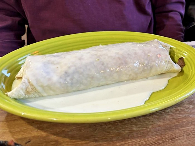 Behold the burrito in its natural habitat: a lime-green plate. This flour tortilla fortress is the comfort food equivalent of a warm hug.