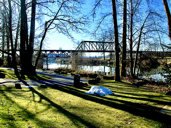 Cady Park offers a perfect riverside respite where nature frames the historic bridge in a calendar-worthy Washington scene.