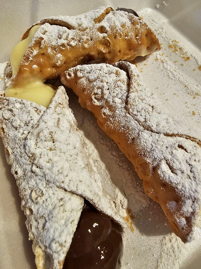Powdered sugar snowcaps on crispy pastry mountains. Orsi's cannoli burst with creamy filling—the kind of dessert that makes you consider licking the plate when nobody's looking.