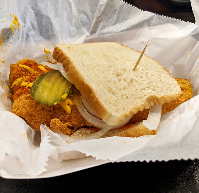 The catfish sandwich comes with pickles and onions, not as garnish but as essential cooling agents for the five-alarm fire in your mouth.
