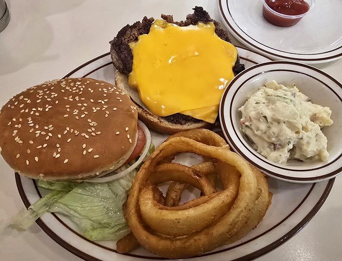 The cheeseburger that time forgot&mdash;sesame seed bun, melty American cheese, and a side of potato salad that your grandmother would approve of.