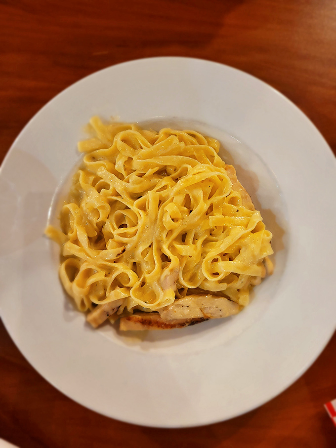 Fettuccine Alfredo that doesn't mess around&mdash;ribbons of pasta swimming in creamy sauce atop what appears to be grilled chicken. Comfort food architecture at its finest.