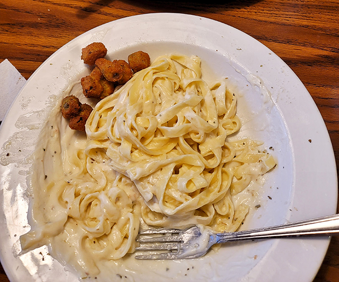 Fettuccine Alfredo so creamy it could make an Italian grandmother weep with joy, accompanied by hush puppies that demand your attention.