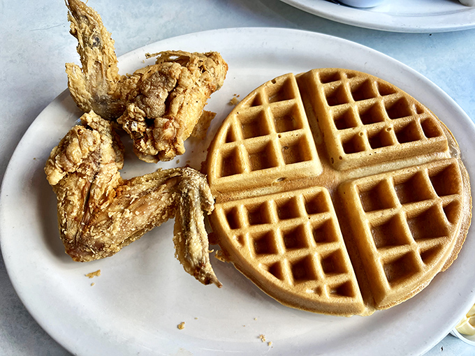The chicken and waffles represent the perfect marriage of breakfast and dinner&mdash;crispy, golden-brown chicken alongside a waffle so perfectly formed it belongs in a geometry textbook.