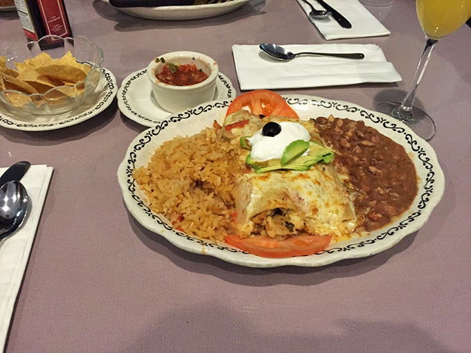A Mexican-inspired fiesta on a plate. Rice, beans, and a cheese-laden enchilada that's doing its best impression of comfort food royalty.