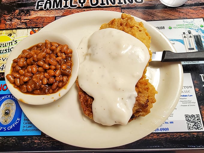 Chicken fried steak smothered in country gravy with a side of baked beans&mdash;a plate that whispers "nap time" in your ear.
