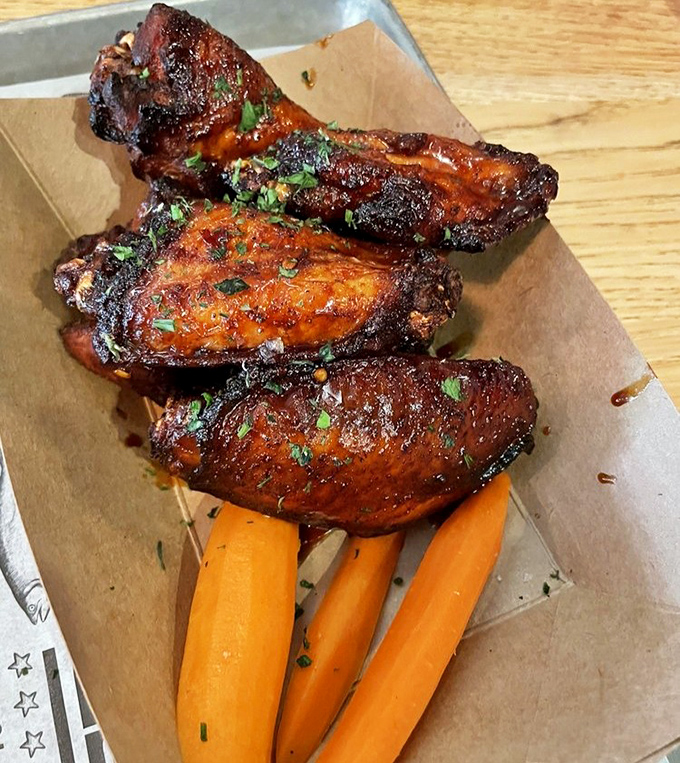 Chicken wings that would make Buffalo jealous, their burnished skin hiding meat so tender it should come with a warning label.