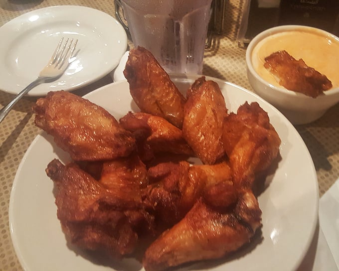 Golden wings glistening with sauce that'll have you reaching for napkins and then immediately reaching for another piece without shame.