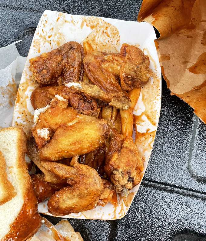 Fried wings bathed in that signature sauce, with obligatory white bread standing by. This is what happiness looks like on a styrofoam plate.