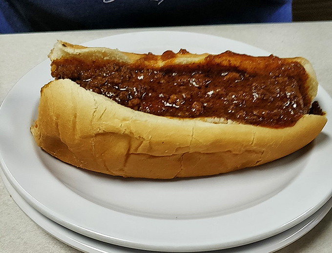 The classic chili dog in all its glory—a perfectly steamed bun cradling a frank smothered in that legendary Carolina-style chili.