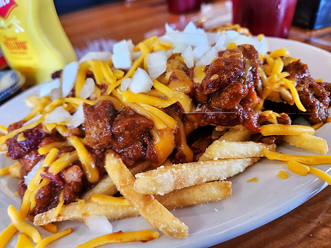 Oh, baby, this is glorious excess! A towering monument of chili, cheese, and crunchy onion over crisp fries. Diner perfection achieved.