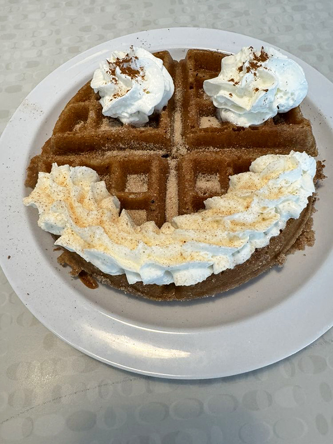 Whipped cream smiles back at you from this cinnamon-dusted waffle &ndash; dessert masquerading as breakfast, and nobody's complaining.