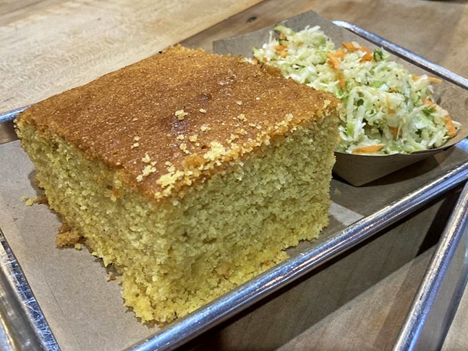 Cornbread so perfect it deserves its own zip code, paired with coleslaw that cuts through the richness. The barbecue golden ratio in action.