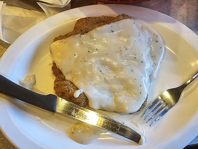 Country fried steak swimming in gravy so good you'll want to write poetry about it. Southern comfort on a plate, no passport required.