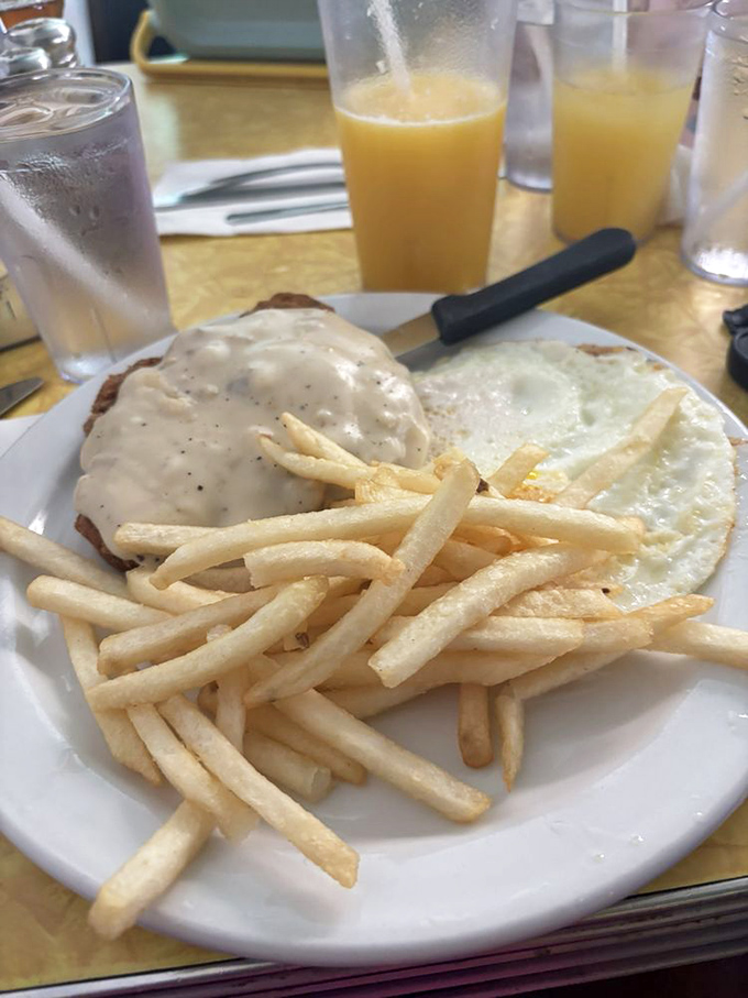 Country fried steak with gravy, eggs, and fries—the kind of breakfast that doesn't just start your day, it fuels an entire adventure.