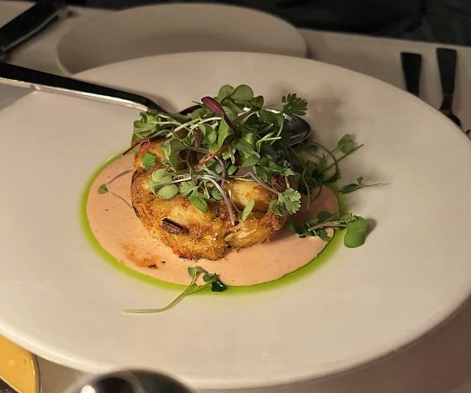 This isn't just a crab cake—it's seafood architecture, delicately balanced on a pool of sauce that deserves its own appreciation society.