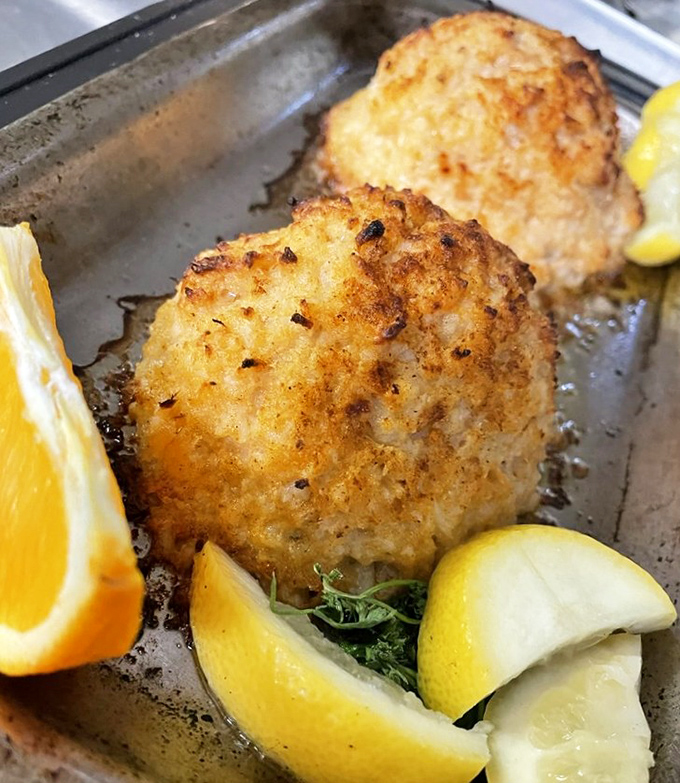 Crab cakes golden as sunrise, with lemon wedges standing by for duty. The kind of seafood that makes you question why you ever eat anything else.