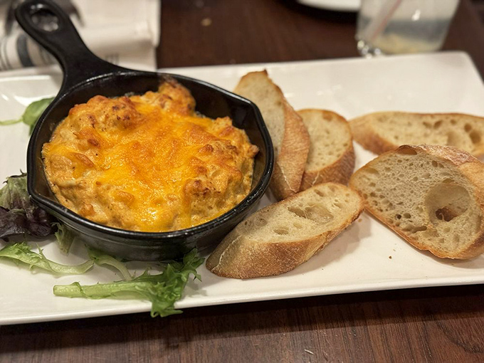 The crab dip arrives bubbling like a savory volcano, threatening to erupt with Maryland flavor all over that perfectly toasted bread.