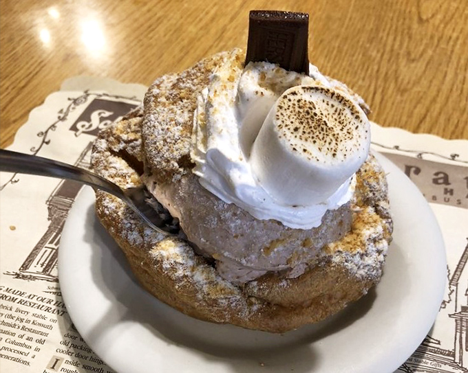 Cream puffs shouldn't be this dramatic. Towering with whipped cream and dusted with powdered sugar, it's dessert theater at its finest.