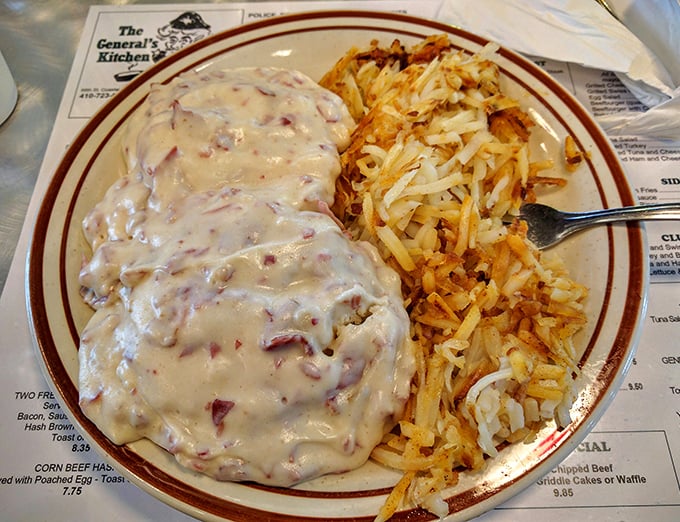 The famous creamed chipped beef blankets the plate like a creamy comfort quilt, paired with golden hash browns that crackle with each forkful.