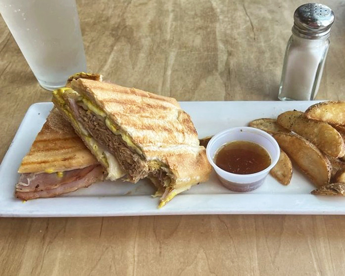 The Cuban sandwich arrives like a well-dressed diplomat: pressed, polished, and ready to negotiate a peace treaty between your hunger and happiness.