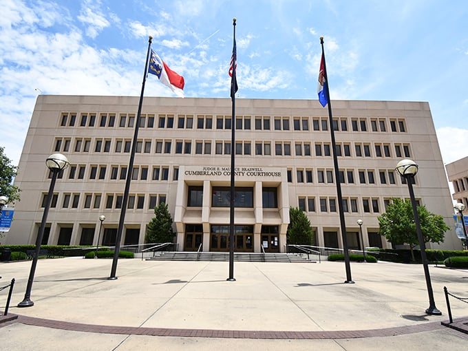 The Cumberland County Courthouse stands as a testament to civic pride, where American flags flutter against Carolina blue skies.