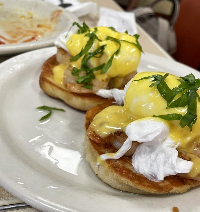 Eggs Benedict that would make a brunch snob weep with joy—perfectly poached eggs, creamy hollandaise, and that touch of green for "health."