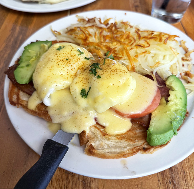 Hollandaise cascading over poached eggs like a delicious golden waterfall that would make brunch gods weep with joy.