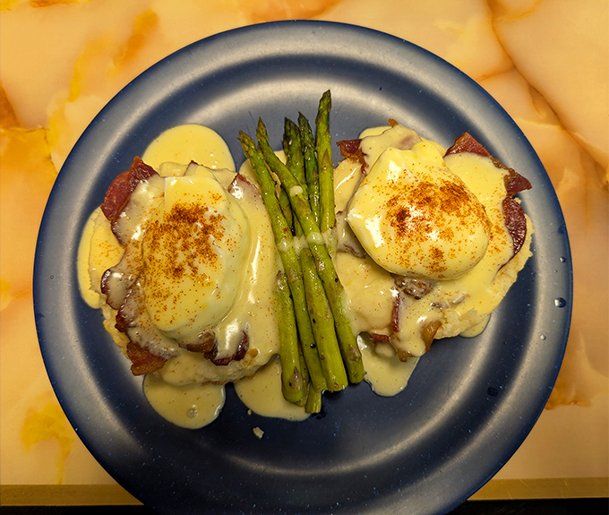 Eggs Benedict with a mountain twist: perfectly poached eggs, asparagus, and hollandaise that would make a French chef weep with joy.