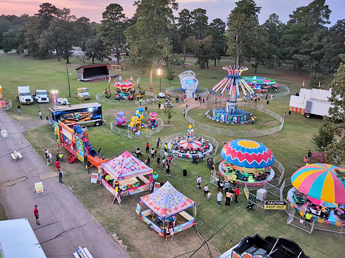 Carnival lights transform the park into small-town magic where community gathers instead of staying home scrolling through other people's fun.