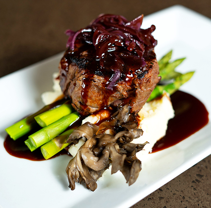 This filet mignon isn't just dinner; it's a masterpiece of culinary architecture with mushrooms and asparagus playing supporting roles to perfection.