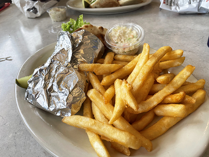 French fries that achieve that mythical balance&mdash;crispy exterior, fluffy interior. The foil-wrapped sandwich hints at treasures waiting to be unwrapped.