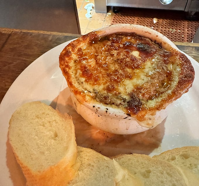 The F Street onion soup arrives like a bubbling cauldron of comfort, cheese melted to perfection atop a rich, savory broth.