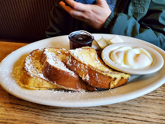 French toast that's achieved the golden ratio of crispy exterior and custardy interior. The powdered sugar snowfall is just showing off.