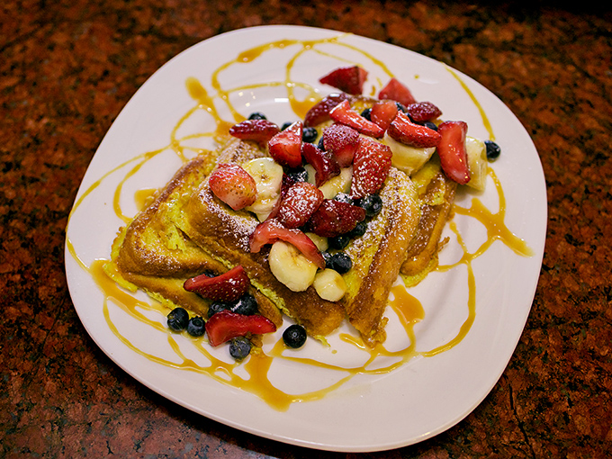 French toast that's dressed for success, wearing berries and bananas like jewelry at a breakfast gala.